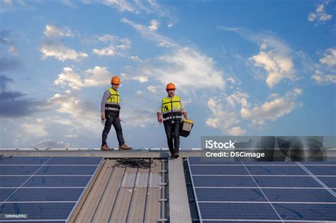 지붕 위를 걷는 엔지니어는 보류 장비 상자 및 무선 통신에 의해 태양 전지 패널을 검사하고 점검하며 태양 전지는 스마트 그리드