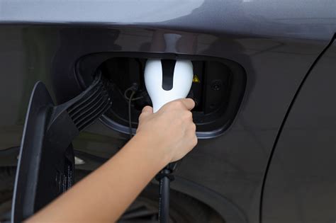 여자의 손이 차를 Ev 충전에 넣습니다 전기 자동차 낮에 도시 주차장에서 전기 자동차 충전 클로즈업 교통수단에 대한 스톡 사진 및 기타 이미지 Istock