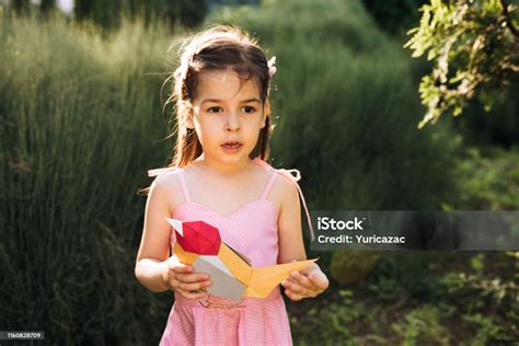 공원에서 종이 다채로운 새를 들고 귀여운 소녀 야외에서 새 장난감을 가지고 노는 호기심 어린 아이 생태 및 환경 개념 어린 시절 아이는 자연을 보호 배려에 대해 학습 개념에