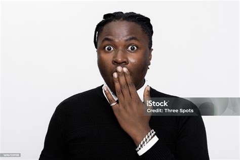 깜짝 놀란 미국 남자 잘생긴 검은 피부 남자가 스튜디오 고립된 감정 표현 개념에서 하얀 배경 위에 입을 벌리고 있는 얼굴 가까이 손을 잡고 있다 가격에 대한 스톡 사진 및