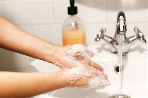 손을 씻는다 욕실에서 흐르는 물의 배경에 비누 거품으로 씻는 손 손바닥을 문질러 독감 질환의 예방 개인 위생 코로나바이러스