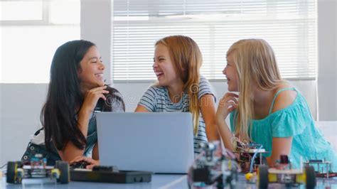 Three Female Students Building And Programming Robot Vehicle In After