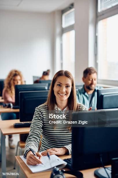 컴퓨터 수업 중에 메모를하고 카메라를 보는 행복한 여성 성인 학생에 대한 스톡 사진 및 기타 이미지 성인 학생 교실 성인 Istock