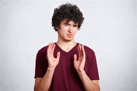 오 아니 날 귀찮게 하지 않습니다 선명 하 고 머리 짜증이 심 술 남성 보여줍니다 거절 제스처 흰색 배경에 대 한 포즈 곱슬 잘생긴 십 대 식 불만족 했다 캐주얼 옷을 입고