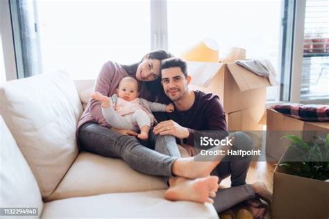 새로운 가정에서 움직이는 아기와 골 판지 상자로 젊은 부부의 초상화 새로운에 대한 스톡 사진 및 기타 이미지 새로운 아파트 젊은 가족 Istock