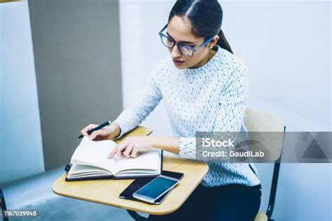 대학 교실에서 숙제를하고 빈 페이지와 메모장에 정보를 작성하는 심각한 여성 학생 영리한 젊은 여성은 대학에서 시험을 완료에 집중 경영자에 대한 스톡 사진 및 기타 이미지