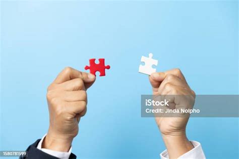 두 손이 파란색 배경에 몇 개의 퍼즐 조각을 연결하려고 합니다 팀웍 개념입니다 직소 퍼즐을 연결하는 손을 닫습니다 조각그림 맞추기에 대한 스톡 사진 및 기타 이미지 Istock