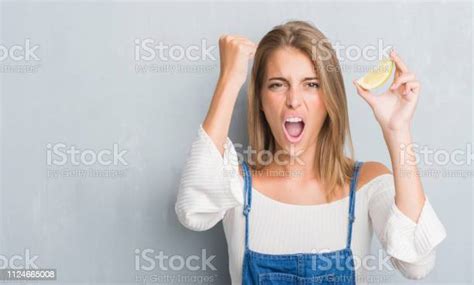 그런 지 회색에 아름 다운 젊은 여 자가 벽 레몬 슬라이스 짜증과 분노 미친 제기 손으로 소리와 좌절 외치고 분노 개념 감정에 대한 스톡 사진 및 기타 이미지 Istock