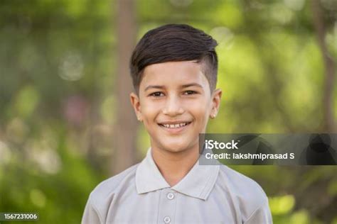 공원에서 카메라를 바라보는 행복한 미소 짓는 인도 소년 아이 개념 장난기 넘치는 표현 야외 행복 즐거운 아이의 개념 소년에 대한