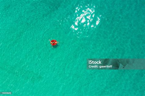 세이셸의 투명 한 청록색 바다에서 수영 링 도넛에 수영 슬림 여자의 공중 보기 소녀 아름 다운 파도 화려한 물과 여름 바다 무인 항공기에서 평면도 보기 공중 뷰에 대한 스톡