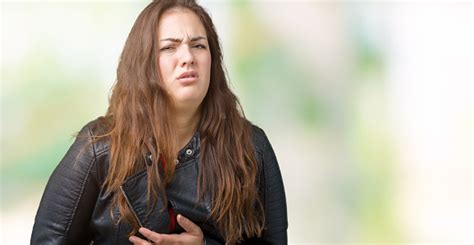 크기 젊은 여자 플러스 아름 다운 이상의 패션 가죽 자 켓을 입고 고립 속에 손으로 배경 때문에 소화 불량 고통 스러운 질병