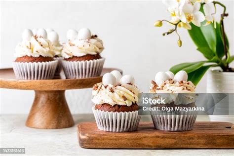 초콜릿 컵케이크 달콤한 사탕 달걀 크림 치즈 둥지가 있는 부활절 테이블 봄 흰 꽃입니다 휴일 수제 디저트 공휴일에 대한 스톡 사진 및 기타 이미지 Istock