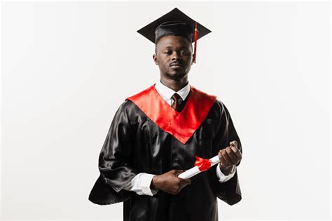 대학을 마칩니다 졸업 가운을 입고 흰색 배경에 모자를 쓴 자신감 있는 아프리카 남자 총각 행복하고 재미있는 아프리카 대학원 남자 미소 학생은 대학에서 석사 학위를 취득하고