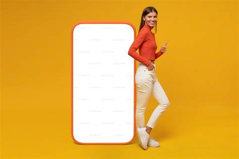 woman standing and showing blank screen of huge phone and thumb up gesture mockup for your app