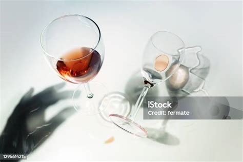 붉은 와인 서 서 밝은 배경에 손의 그림자 파티 또는 알코올 중독 개념의 추상적 인 흔적과 특이한 관점에서 떨어졌다 안경 그림자에 대한 스톡 사진 및 기타 이미지 Istock