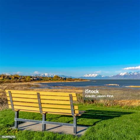 푸른 하늘에 대 한 호수와 눈 덮인 산을 직면 잔디 필드에 프레임 광장 벤치 0명에 대한 스톡 사진 및 기타 이미지 0명