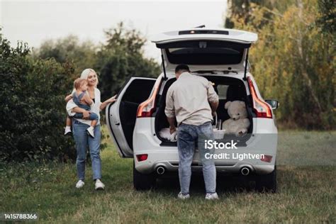 야외에서 피크닉 시간을 준비하는 어린 아이와 함께 두 명의 부모 Suv 자동차로로드 트립을 즐기는 젊은 가족 3 명에 대한 스톡 사진 및 기타 이미지 Istock