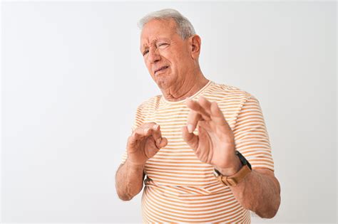 줄무늬 티셔츠를 입은 선임 회색 머리의 남자는 고립 된 흰색 배경 혐오 표정 위에 서 혐오 스러운 반응 때문에 혐오 얼굴을 하고 손을 들고 성가신 개념 T 셔츠에 대한 스톡