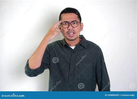 Adult Asian Man Showing Angry Expression With His Finger Pointing To Side Forehead Stock Image