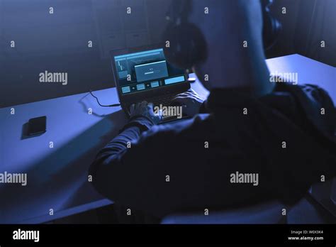 Hacker With Loading Bar On Laptop In Dark Room Stock Photo Alamy