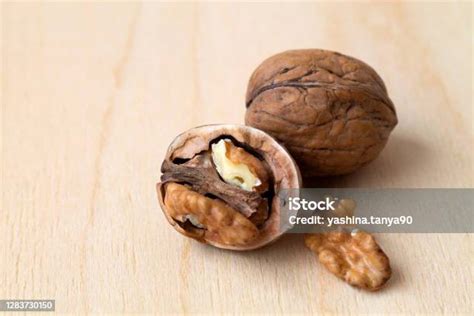 나무 테이블과 유리 항아리에 껍질을 벗기지 않은 호두를 클로즈업합니다 밝은 배경에 갈색 너트 복사 공간을 복사합니다 0명에 대한