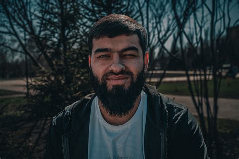 Мужчина сидит на корточках на берегу озера на закате · Бесплатные стоковые фото