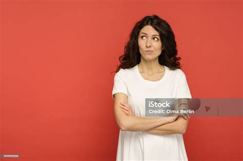 빨간 벽에 빈 복사 공간을 옆으로 회의적인 얼굴로 비꼬는 의심 스러운 여자 판단 모습 여자에 대한 스톡 사진 및 기타 이미지 여자 한 명의 여자만 의심 Istock