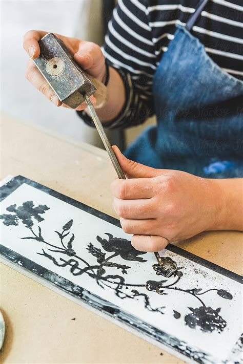 Artisan Woman Using Hammer And Chisel To Engrave A Slate Stone By
