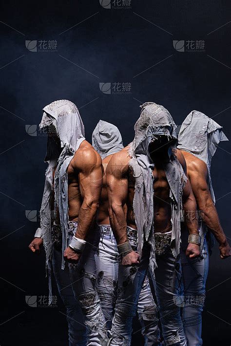 四个肌肉发达的哥特男人赤裸着上身站在黑色背景上。神秘和秘密的概念