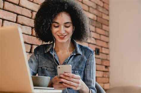 현대 식당에서 노트북과 전화를 사용하여 20 년대 아프리카 계 미국인 소녀를 미소 20 24세에 대한 스톡 사진 및 기타 이미지 20 24세 25 29세 곱슬 머리