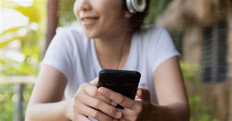 야외에서 헤드폰과 스마트폰으로 음악을 듣고 있는 행복한 아시아 여성 재미 느긋한 사진 Unsplash의 성공 이미지