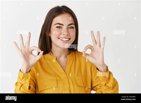 Close Up Of Smiling Young Woman Assuring You Showing Okay Sign And