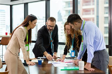 문서 브레인스토밍 또는 회사에서 프로젝트를 논의하는 대화와 함께 회의 테이블에 서있는 다문화 기업 동료 그룹 팀워크 다양성 및 사무실 개념 기업 비즈니스에 대한 스톡 사진