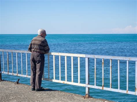 Premium Photo Lonely Man On The Pier Rest On The Seashore Escape From