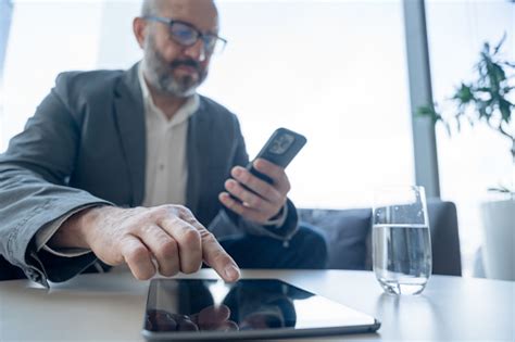 현대적인 사무실 환경에서 스마트폰과 태블릿을 사용하는 사업가 Brand Name Smart Phone에 대한 스톡 사진 및 기타 이미지 Brand Name Smart