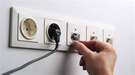 Close Up Of A Womans Hand Connecting An Ethernet Cable To A Network Close Up Of A Womans Hand Connecting An Ethernet Cable To A Network