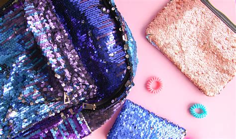 패션 액세서리와 드레스의 구성 반짝이는 스팽글스위트샷 지갑 배낭 화려한 폼폰 헤어 밴드 부드러운 핑크 파스텔 배경의 다른