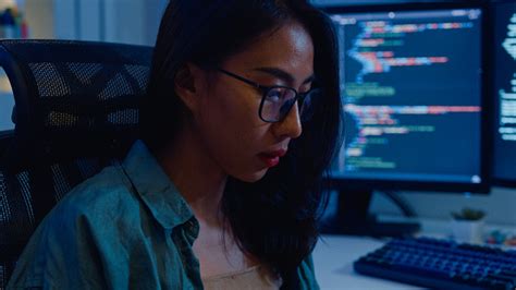 젊은 아시아 여성 소프트웨어 개발자는 컴퓨터를 사용하여 여러 화면이 있는 책상에 앉아 코드를 작성합니다 데이터에 대한 스톡 사진