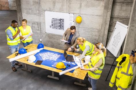 Premium Photo Team Of Structural Engineers And Architects Analyzing Plans And Blueprints At
