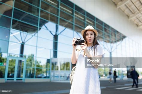 젊은 배낭 보류 복고풍 빈티지 사진 카메라로 국제 공항에서 여행자 관광 여자 모자에 충격 여성 승객 주말도 주에 여행을 해외 여행 공기 비행 개념입니다 건축에 대한 스톡