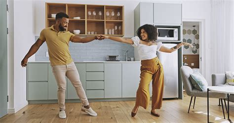 집에서 춤을 추는 커플 남편과 아내는 재미 있고 춤을 추고 있습니다 여자 친구와 남자 친구는 장난기가있다 주말에 춤을 추는 법을 배우는 남자와 여자 여자와 남자가 함께