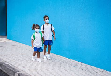 아이들은 의료 용 얼굴 마스크를 착용하는 동안 손에 함께 함께 집으로 걸어 학교와 코로나 바이러스에 대한 새로운 안전 조치 2 3 살에 대한 스톡 사진 및 기타 이미지