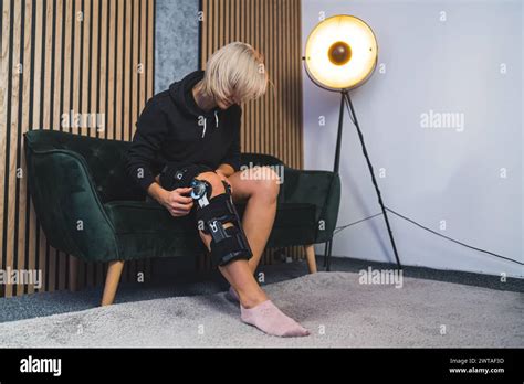 A Caucasian Woman Fitting Leg Compression Brace While Sitting On The