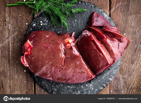 Сырая печень на доске на деревянном фоне вид сверху — Стоковое фото © Yelenayemchuk 146269745