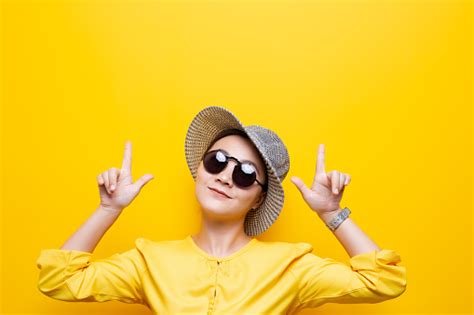 선글라스와 모자를 착용 하는 초상화 여자 노란색 배경 위에 고립 된 공간을 복사 하는 포인트 가리키기에 대한 스톡 사진 및 기타 이미지 Istock