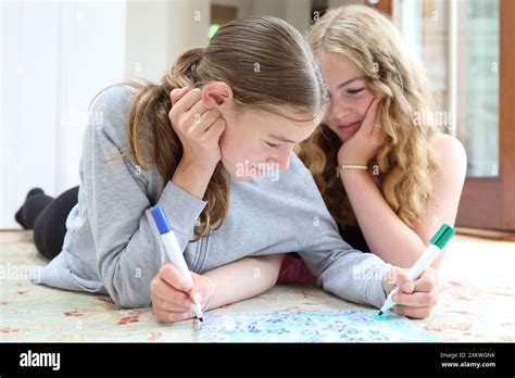 Two Girls Smiling Doing Maths Math Lying On Floor Writing On Whiteboard With Pens Algebra