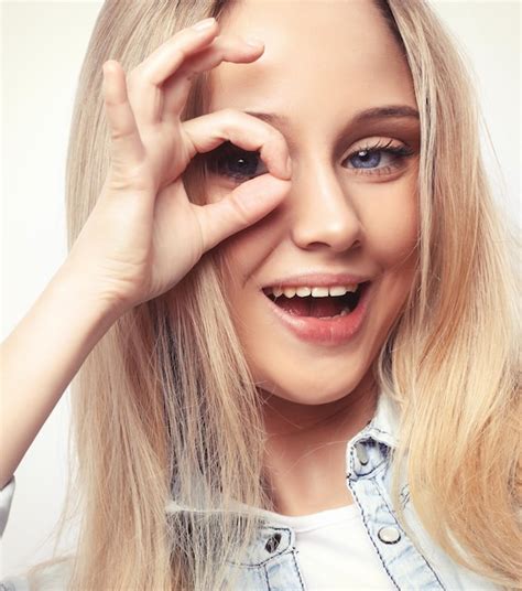 Premium Photo Happy Excited Young Woman Looking Through Hole Made Of Her Fingers Over White