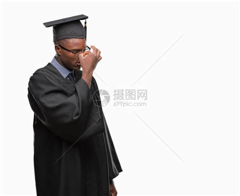 年青的非洲毕业男子在孤立的背景中疲惫地擦鼻子和眼睛高清图片下载 正版图片505456654 摄图网