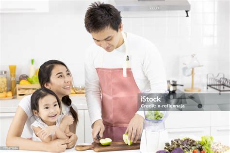 부엌에서 행복한 아시아 가족입니다 아버지 어머니와 딸은 집에서 테이블에 믹서기 메뉴 맛있는 스무디와 재료에 샐러드를 준비하고있다 요리 음식 건강한 음식 개념 4 5세에 대한