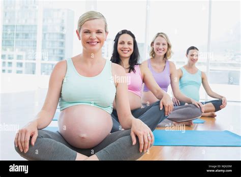 Happy Pregnant Women In Yoga Class In Lotus Pose In A Fitness Studio